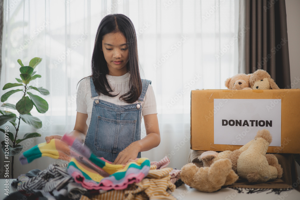 Recycling, Donation for poor, Asian girls packing objects at home, putting on stuff into donate ...