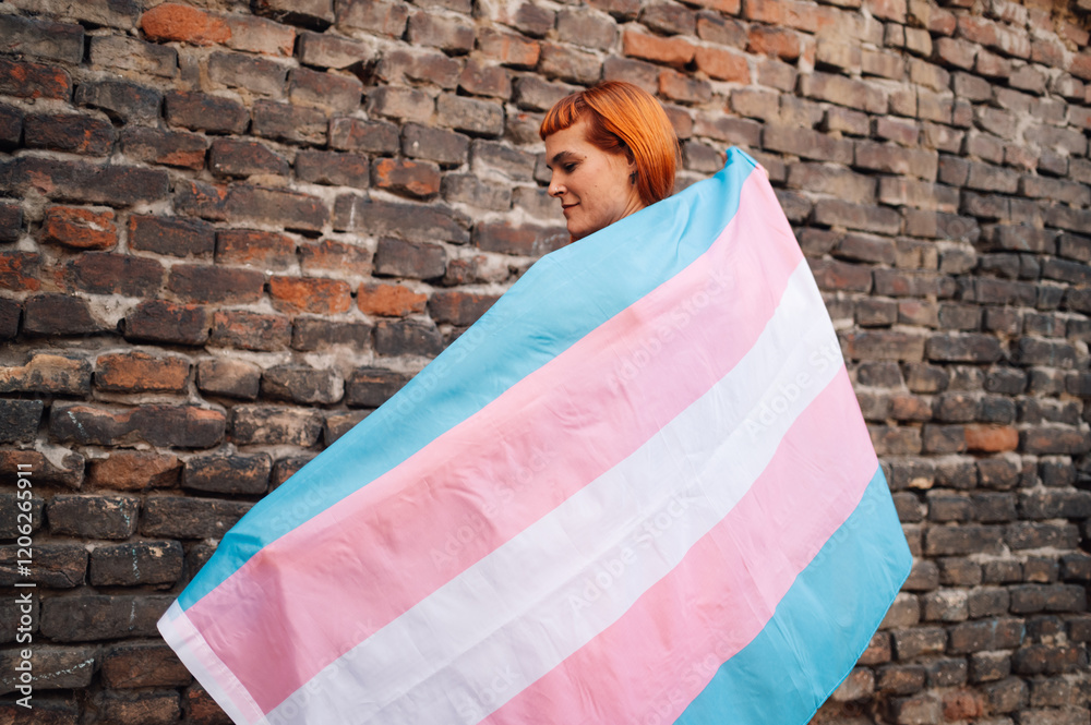 Young activist showing transgender pride flag against brick wall Stock ...