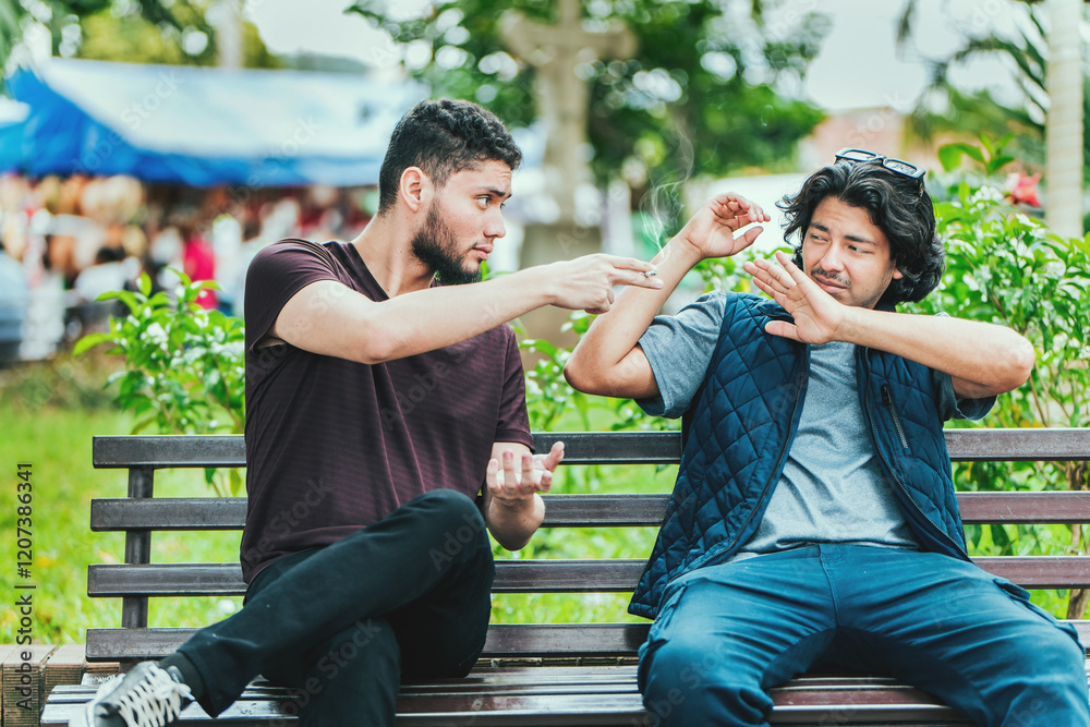 Young man sitting refusing a cigarette in the park. Disgusted guy ...