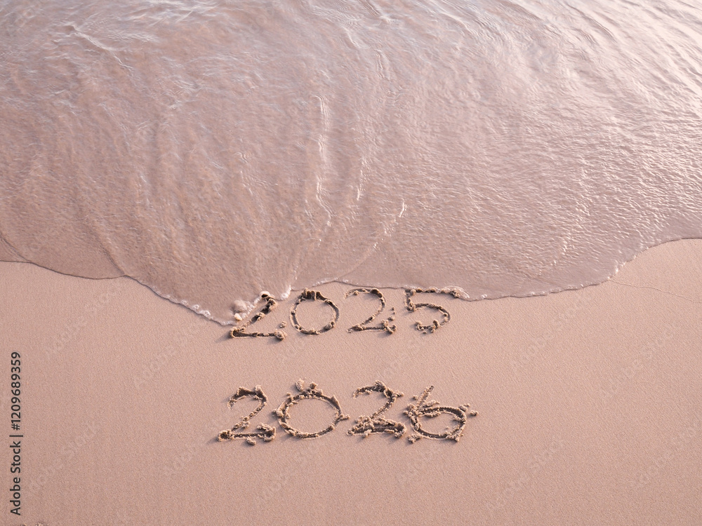 ภาพถ่าย Stock Handwritten inscription 2025 and 2026 on the beach in the sunset time. The concept ...