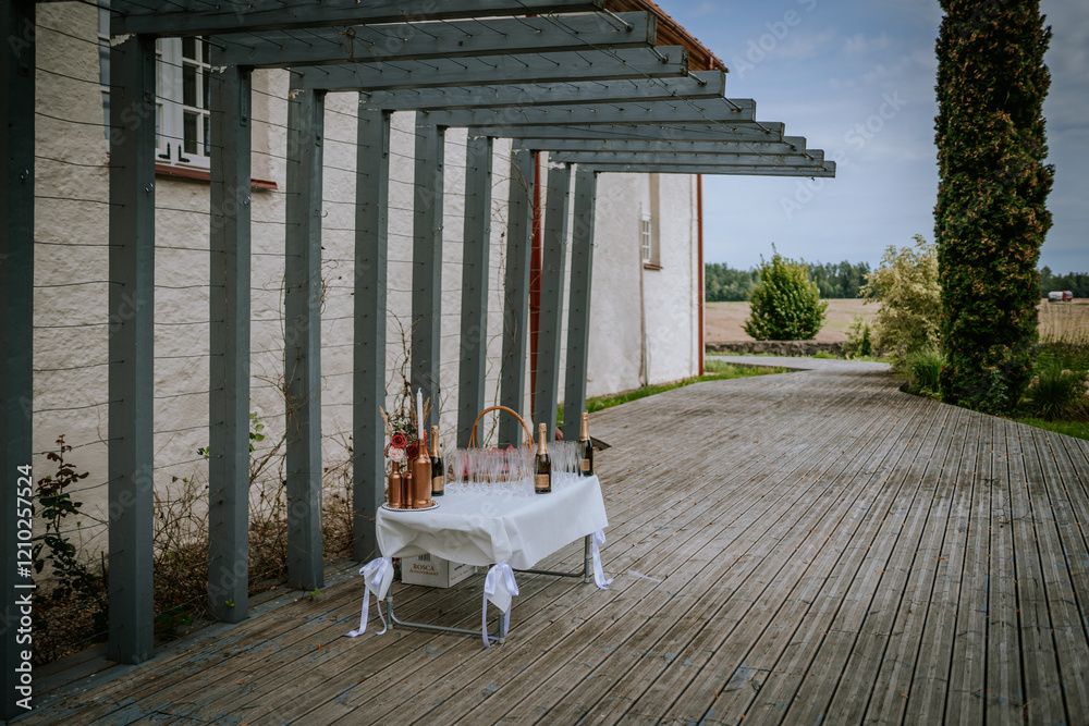 Outdoor setup with a decorated table featuring champagne bottles and ...