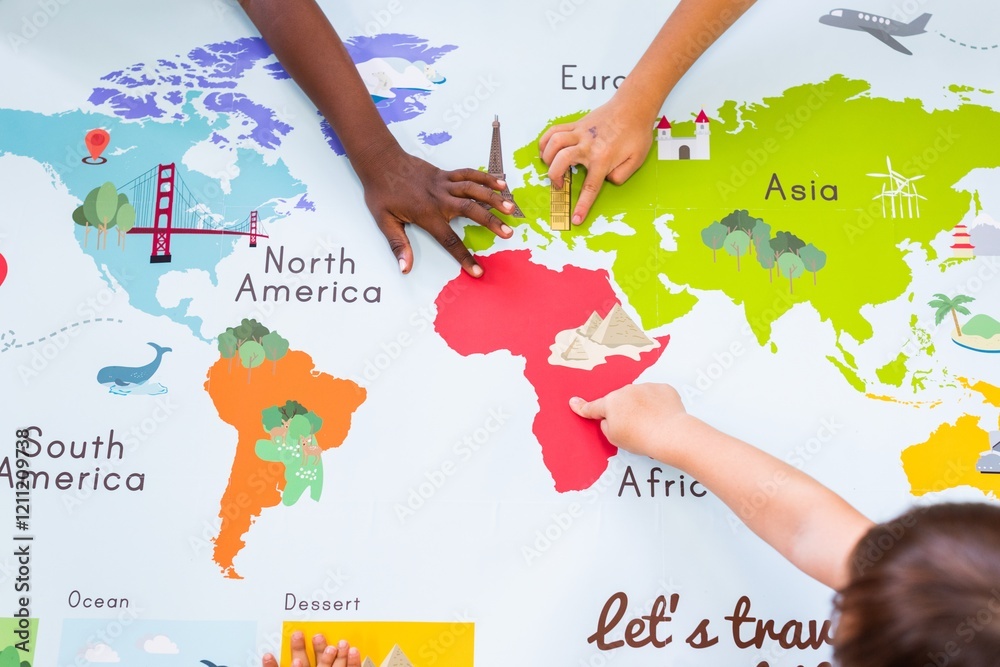 Foto de Stock Children's hands exploring a colorful world map. Kids ...