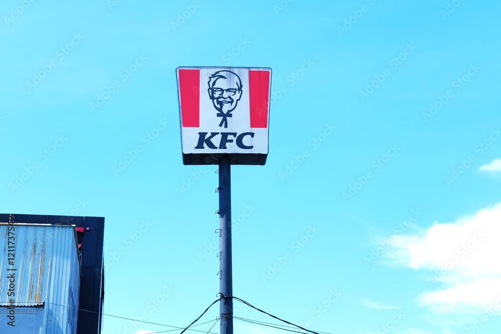 A tall KFC signboard featuring the iconic Colonel Sanders logo stands ...