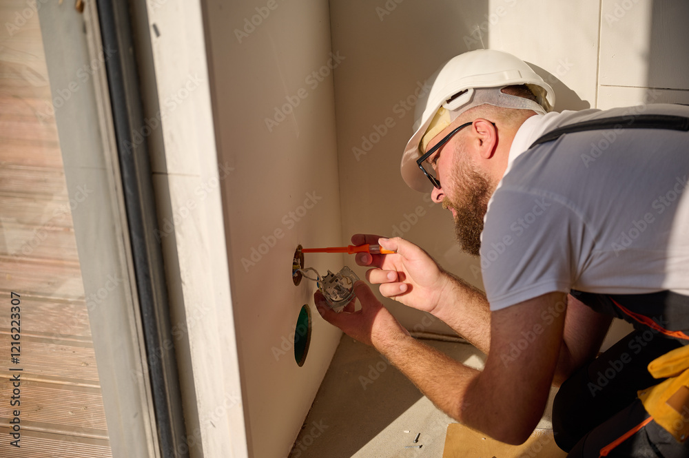 Builder installing electric socket in new apartment. Installing ...