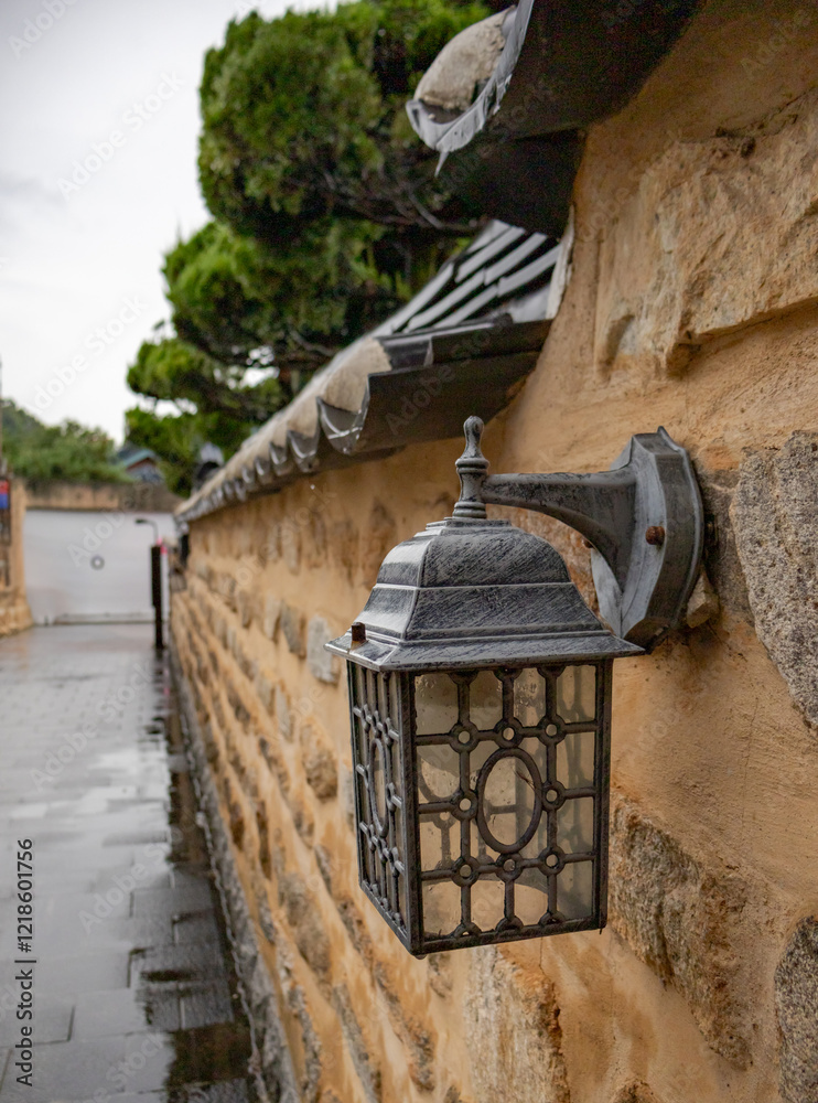 Old traditional metal lamp post on a stone brick wall. Photo taken in ...