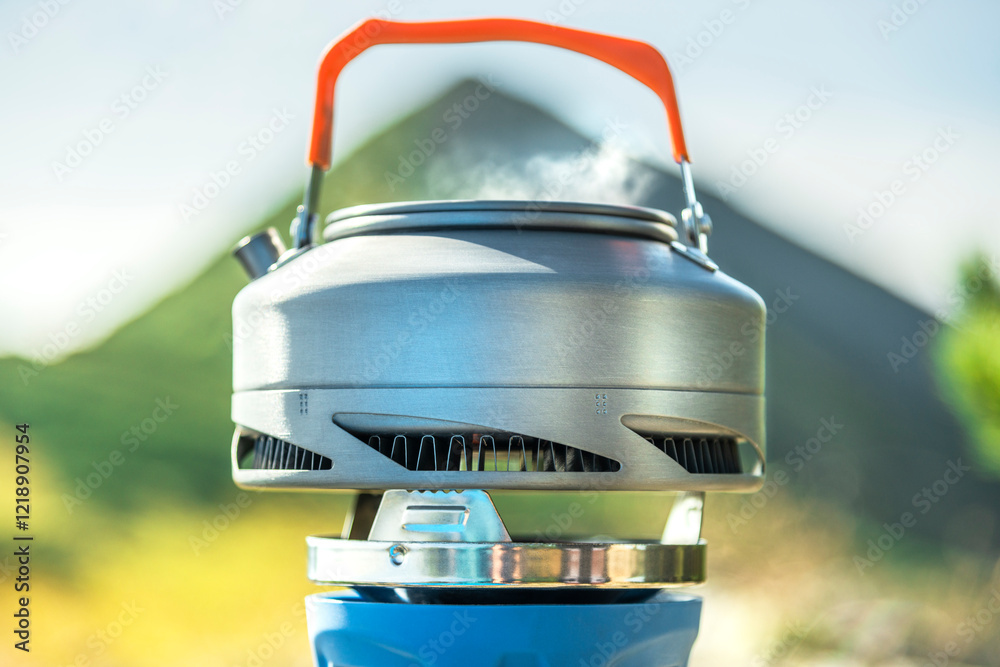 Camping kettle boiling on a tourist gas stove with steam rising ...