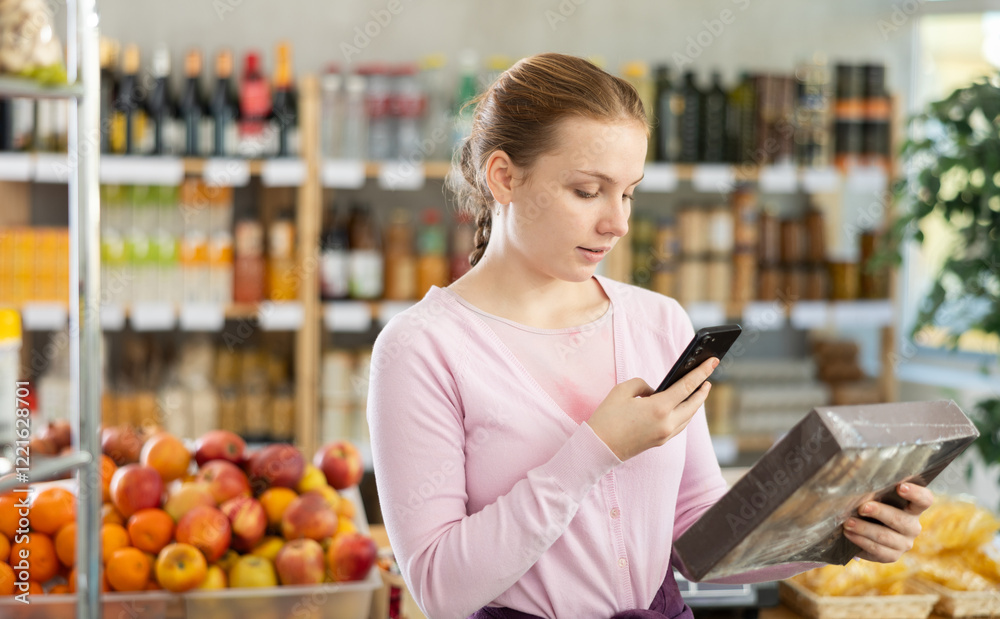 Young girl buyer scanning qr code for box of cookies in grocery store ...