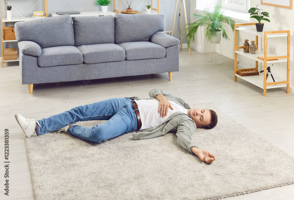Unconscious young man lying alone on floor in living room at home with ...