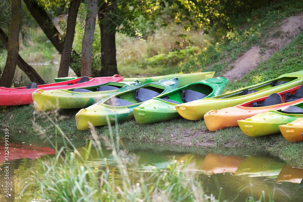 Many canoes of different colors on the river bank before training ...