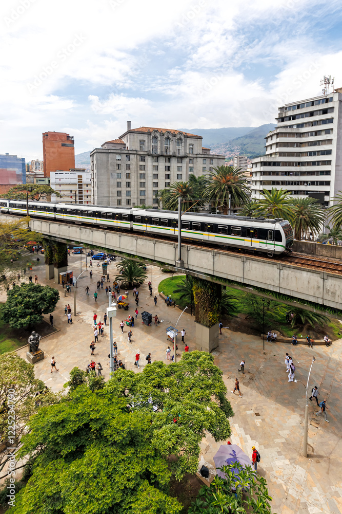 Medellin skyline with Metro de Medellín train at Plaza Botero portrait ...