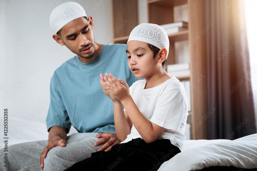 Islamic father and son praying together indoors during ramadan kareem ...
