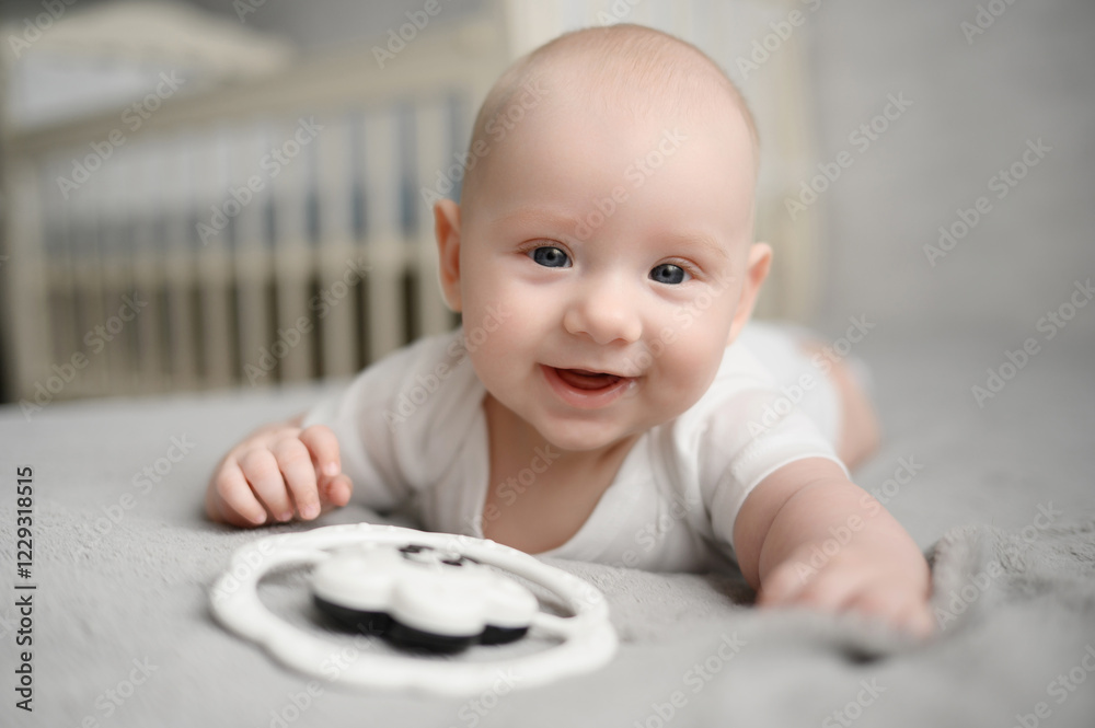 Cute smiling baby lies on comfortable bed on stomach, awake after ...