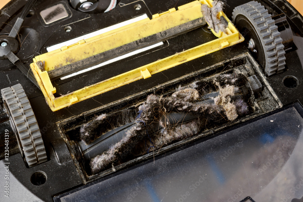 Partially disassembled robotic vacuum cleaner showing a dirty, dust ...