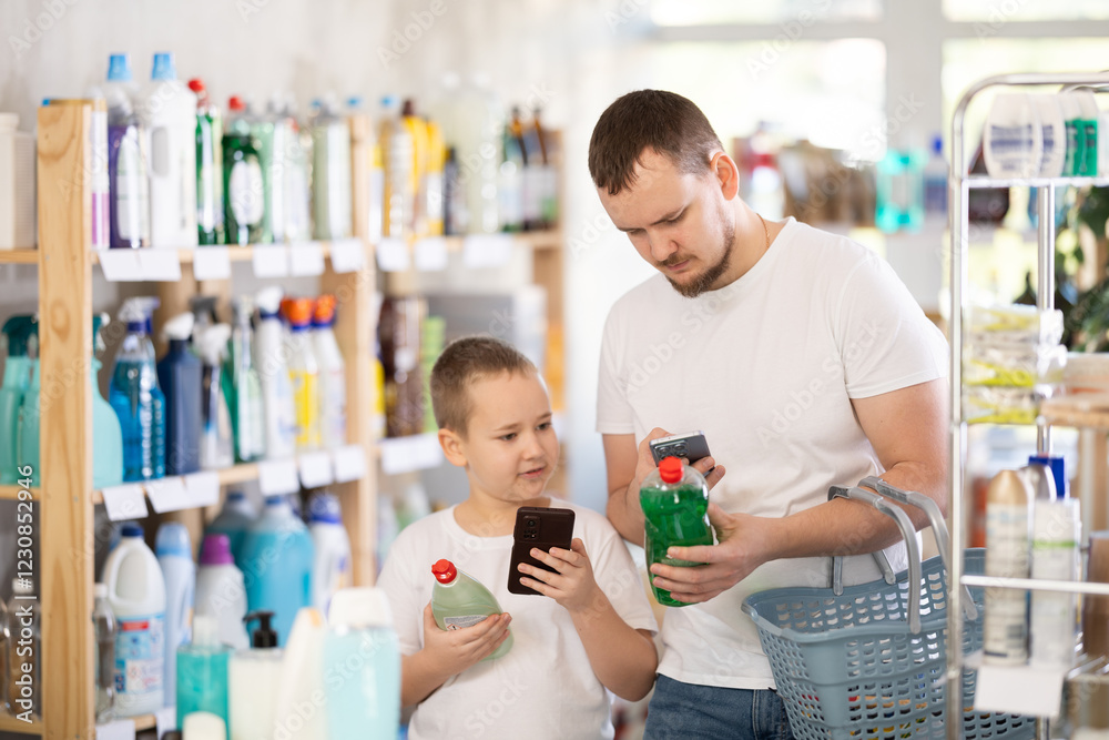 Dad teaches his son to scan QR code on package of dishwashing. Store ...