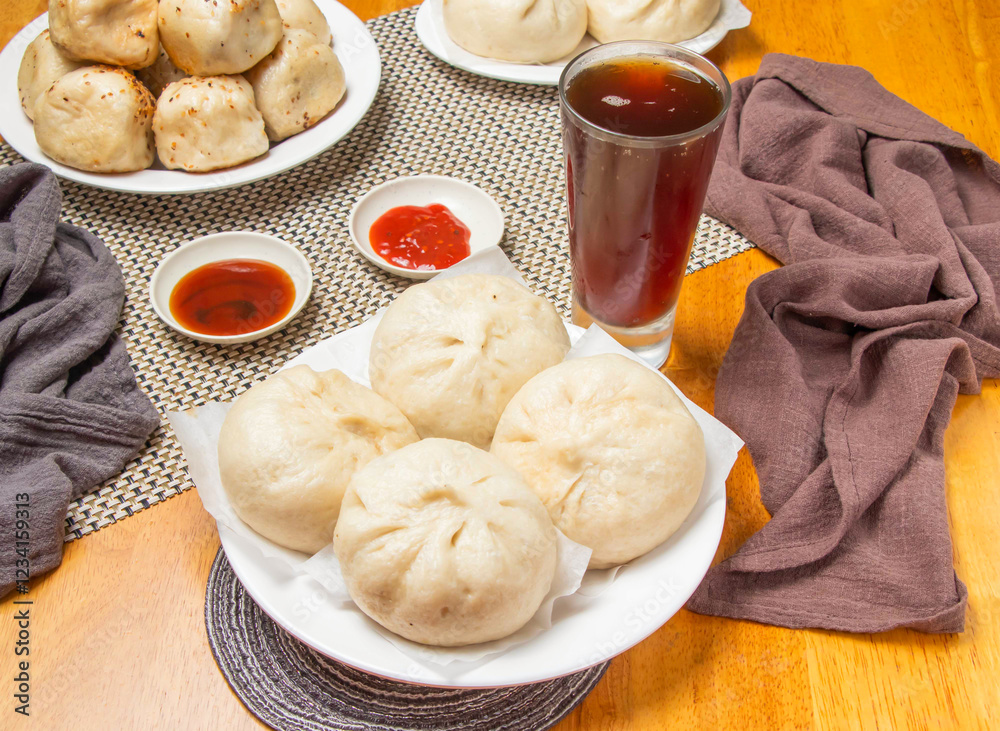 4 steamed pepper meat buns with Dipping Sauces and a tall glass of iced ...