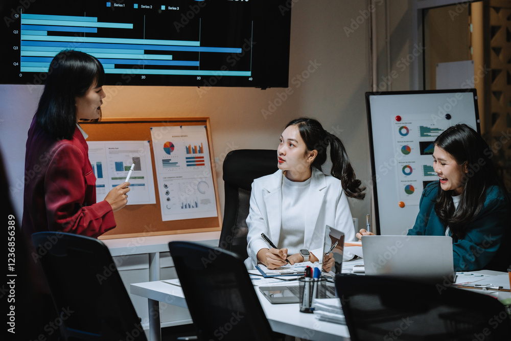 Asian businesswomen working late analyzing financial charts using data ...