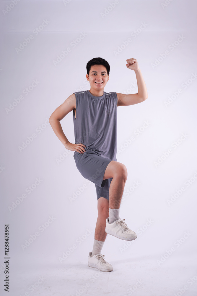 Full body image of Asian guy wearing gym clothes and posing on a white ...