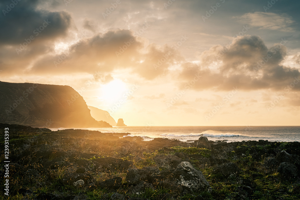 Sun ascends behind Motu Marotiri Stake and Cape Roggeveen, located on ...
