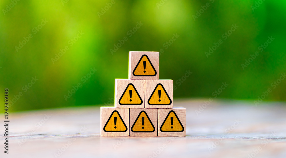 Wooden blocks arranged in pyramid shape displaying yellow warning signs ...