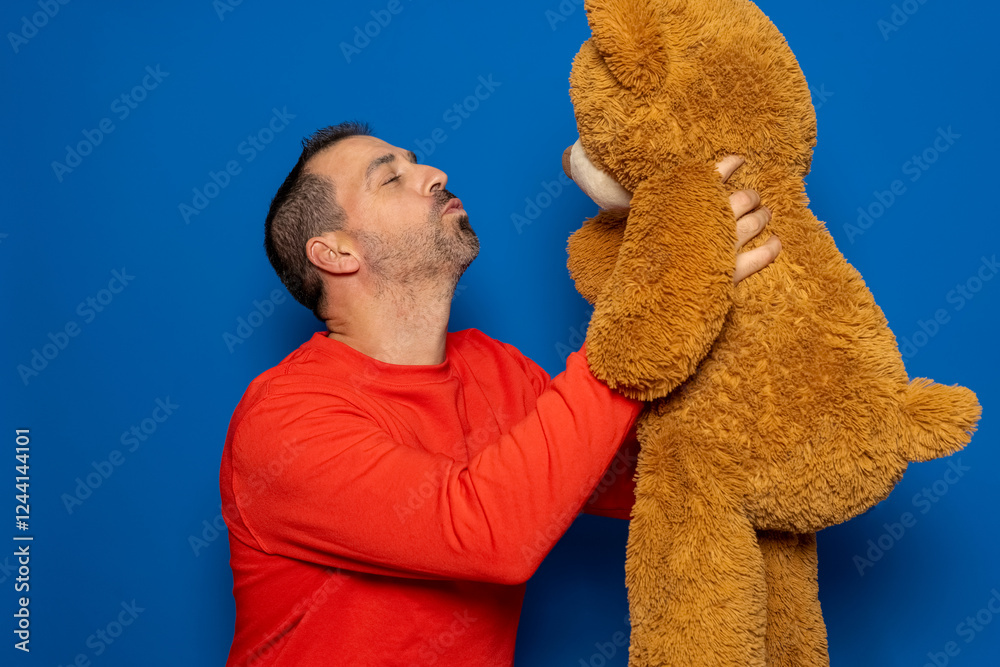 Bearded hispanic man in his 40s wearing a red sweater holding up a ...