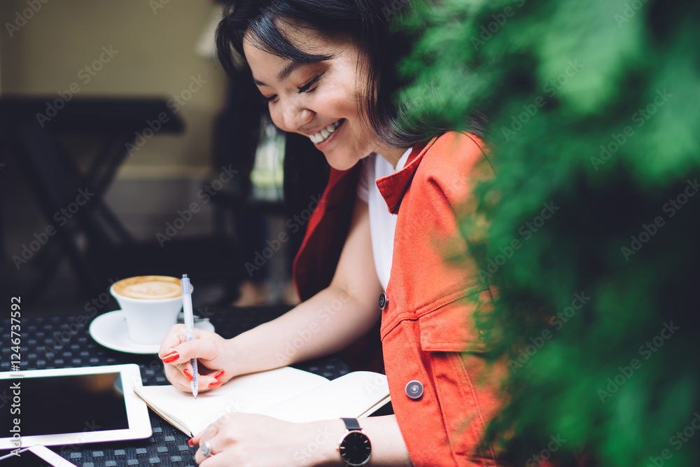 Excited ethnic woman writing down ideas in outdoor cafeteria Stock ...