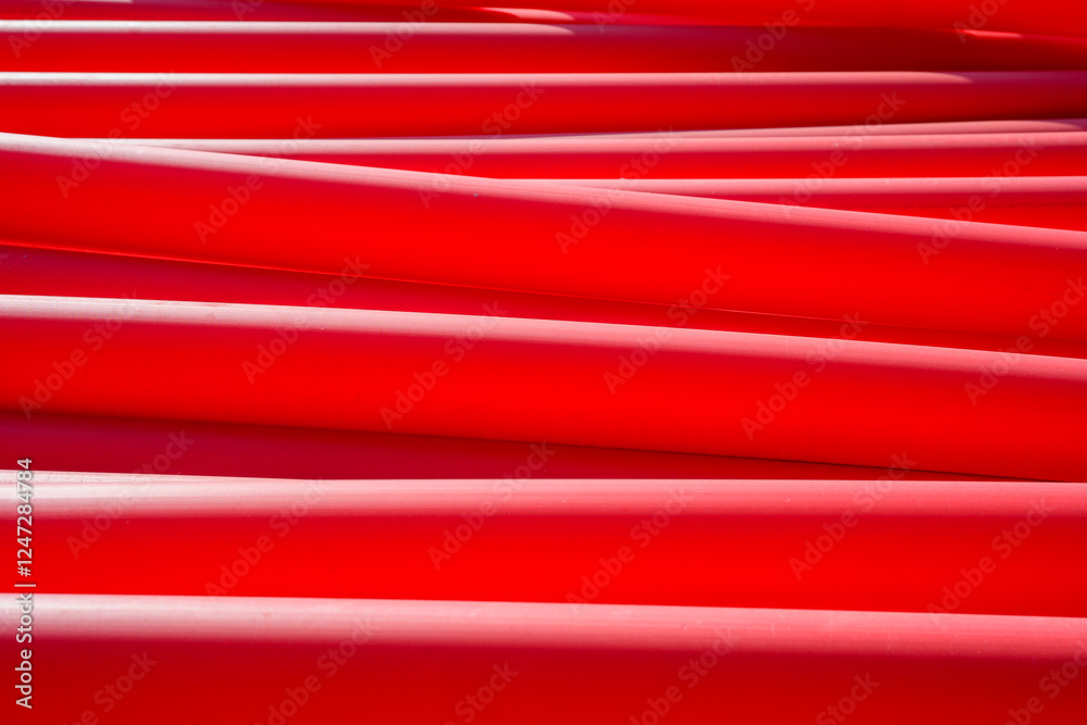 Red plastic polymer pipes on construction site, used for the creation ...