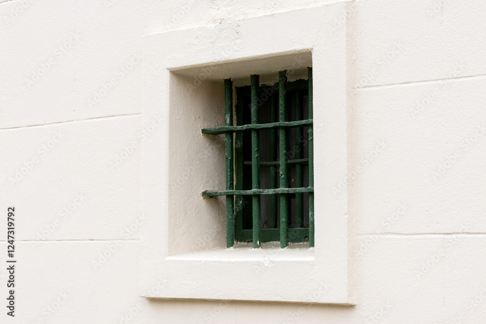 Diagonal view of a square window with bars in the old prison that is ...