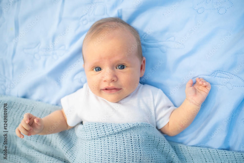 baby boy is crying. upset child is lying on bed. the child is 1 month ...