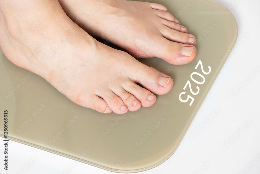 Women's feet on floor scales and on the dial the number 2025, new goals ...