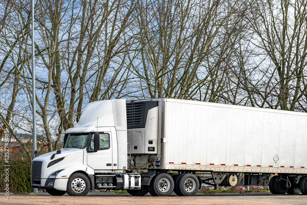 Day cab white big rig semi truck with huge roof spoiler transporting ...
