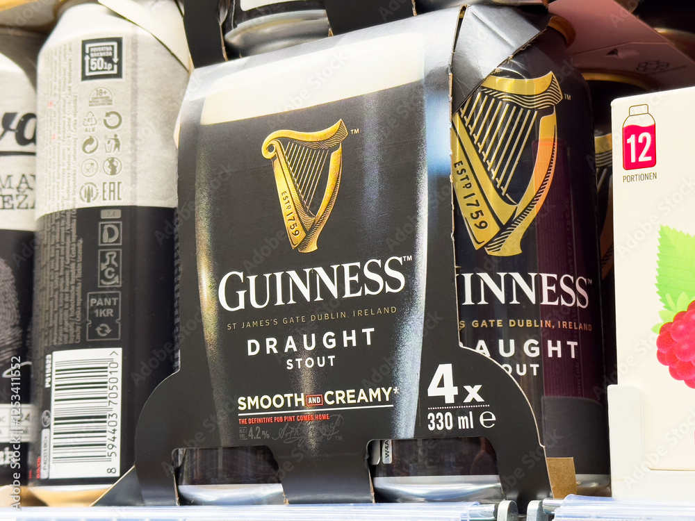 Guinness draught stout cans on store shelf with iconic harp logo and ...