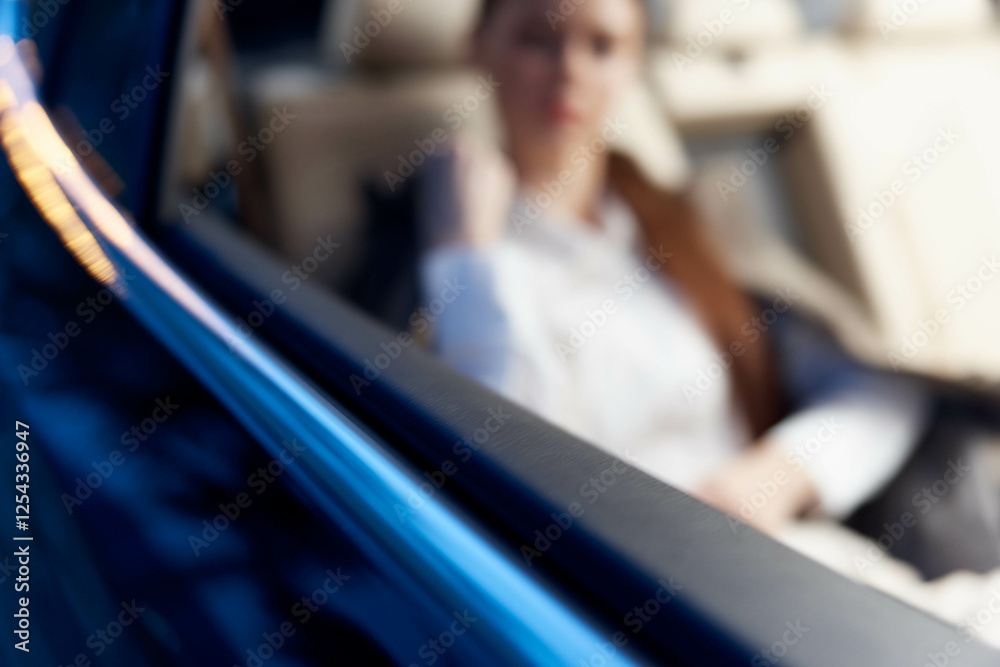 Woman in car back seat, hand on steering wheel and door handle, looking ...