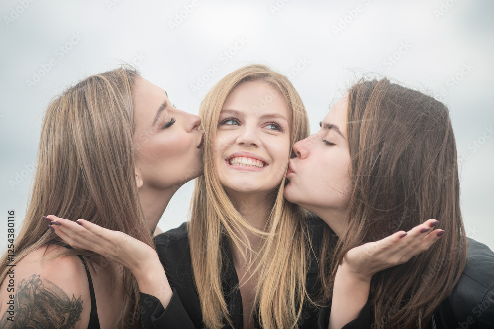 Three girls kissing on the cheeks, close-up face. Young women hugging ...