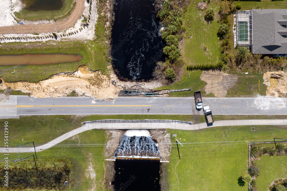 Construction trucks blocking road access at destroyed bridge after ...