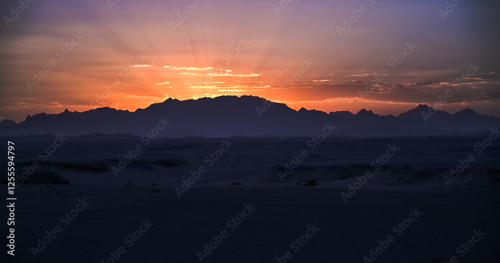 Desert sunset in Egypt, with a strong sunlight from behind the mountain ...