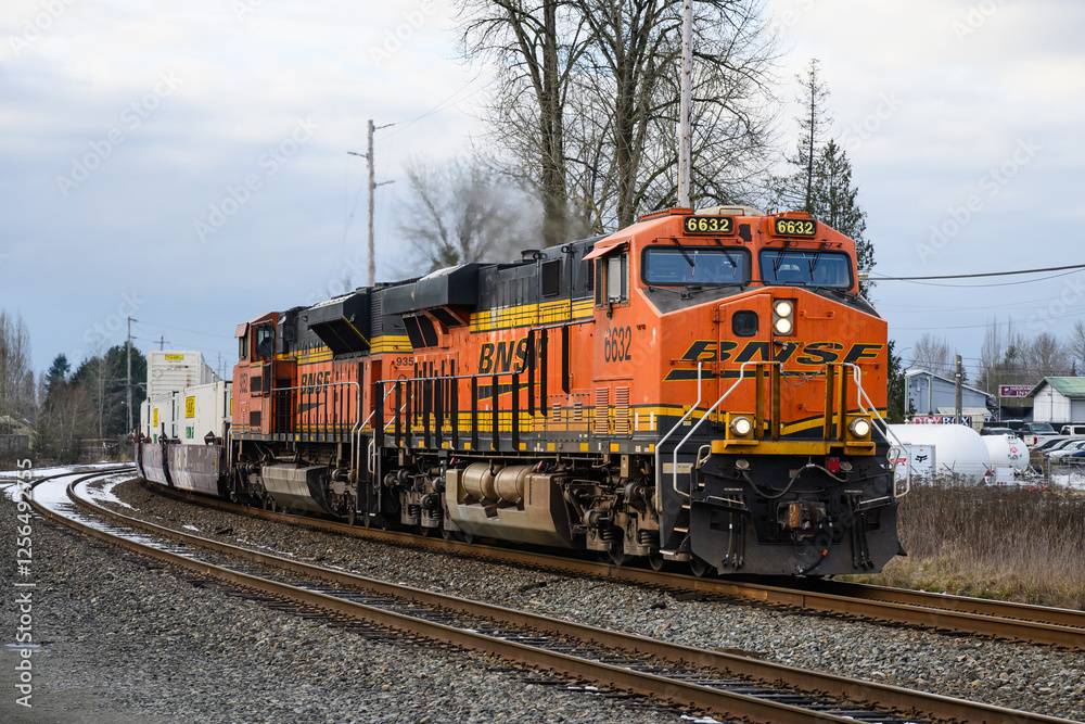 Monroe, WA, USA - February 7, 2025; BNSF intermodal freight train in winter on curved track ...