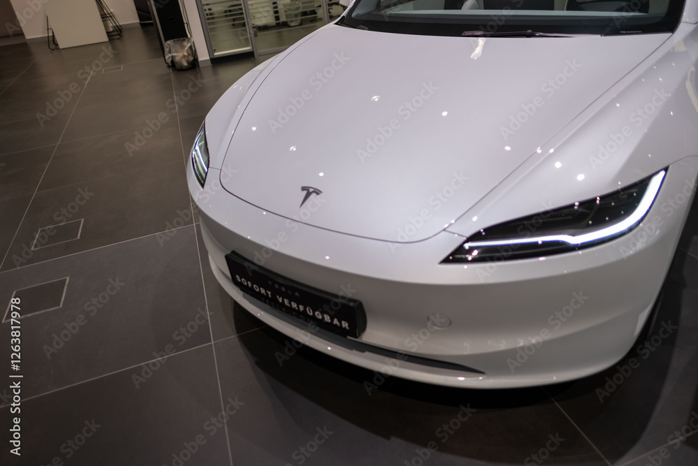 White Tesla Model 3, futuristic headlights displayed in modern showroom ...