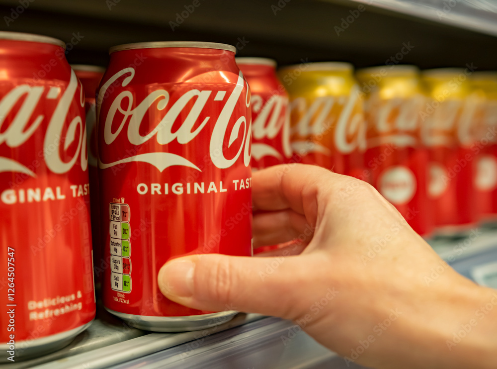Human hand taking red can of Coca-Cola from shelf in supermarket close ...