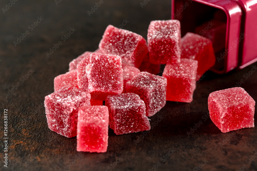 A view of a pile of edible red sour candy spilling out of the package ...