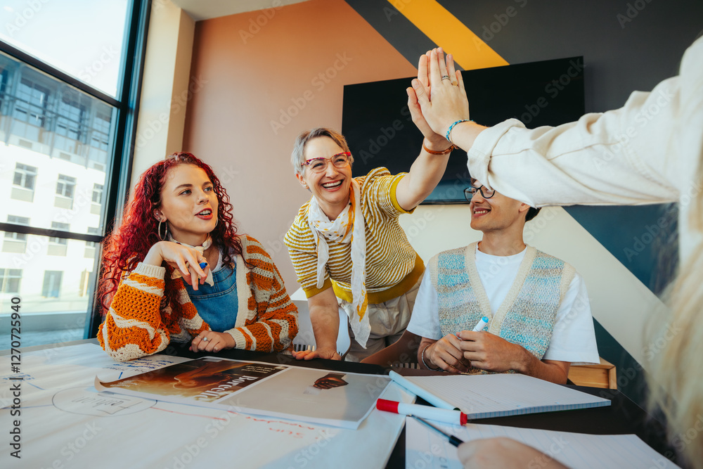 Energetic teacher high-fiving students in a high school classroom ...