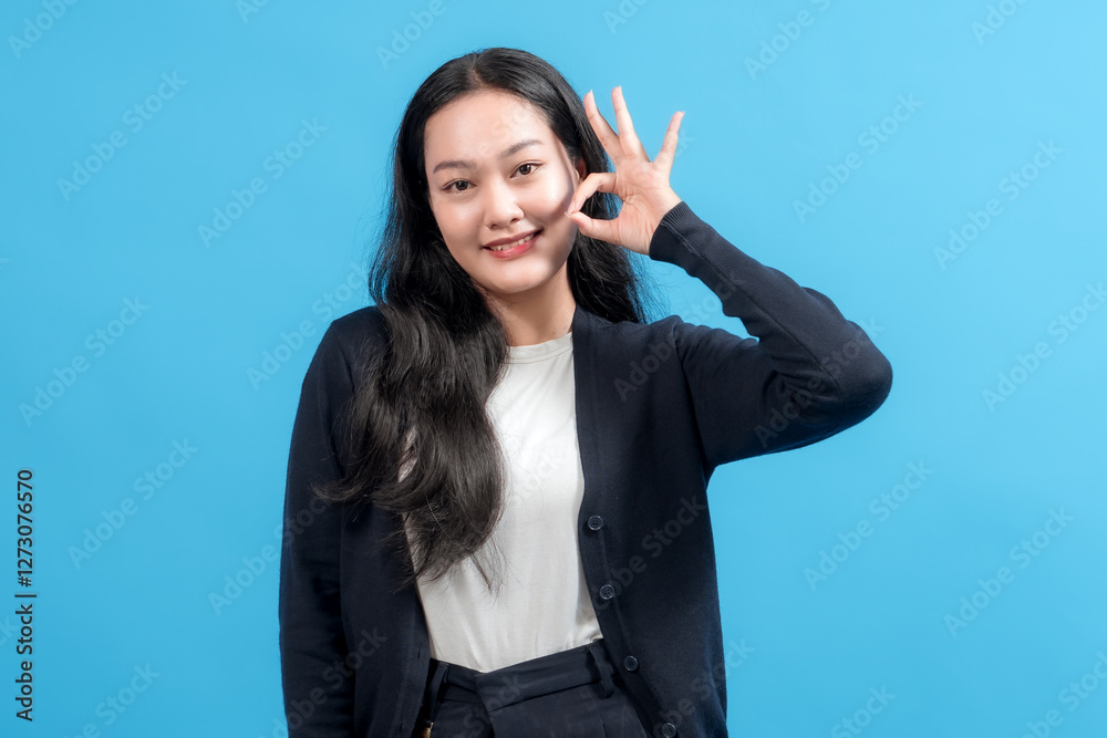 Confident young woman expressing positivity with a hand gesture, posing ...