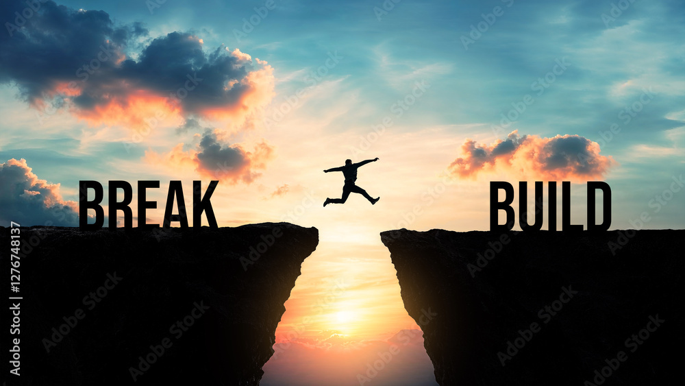 Silhouette of a person jumping from break to build over a gap between ...