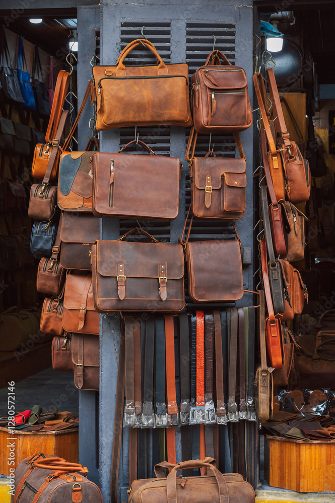 handmade leather bags, belts and accessories on counter in shop at a ...