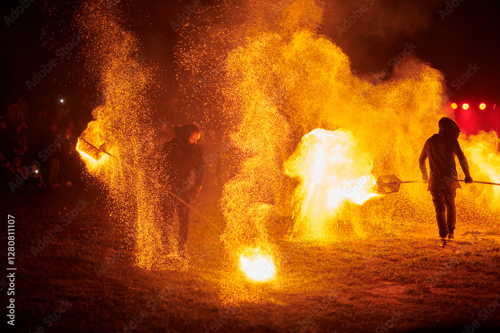 Silhouette of two fire performers with sparkling fire staff erupting in ...
