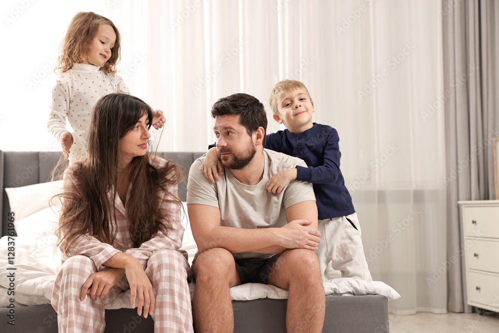 Playful children and their overwhelmed parents on bed at home Stock ...