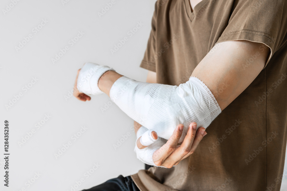 Young man with gauze bandage wrapped around his injured arm. Man with ...