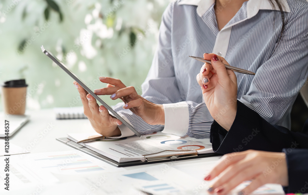 Professional team analyzing financial reports and data in a modern ...