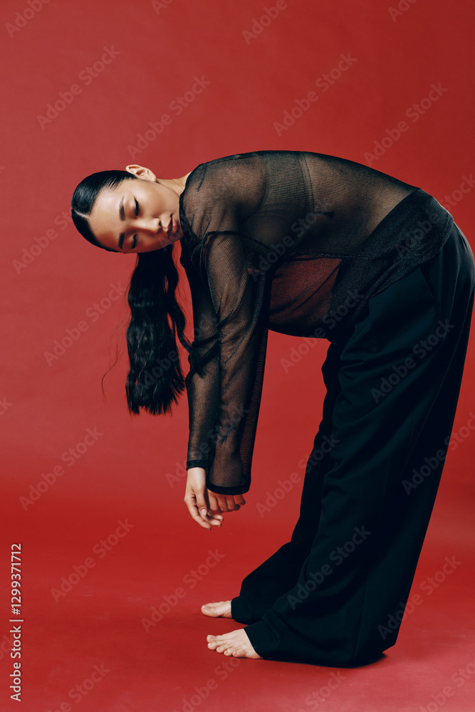 Fashion asian woman wearing a sheer top and black pants, bending over ...