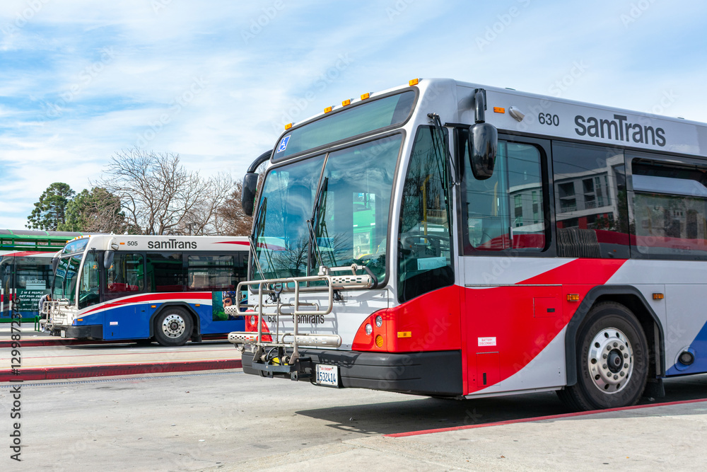 Two SamTrans buses in red, white, and blue livery parked at a transit ...