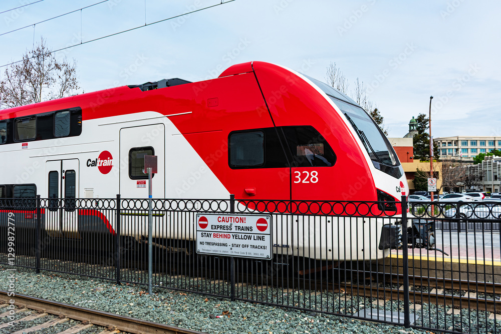 Red and white Caltrain train labeled 328 is parked at a station ...